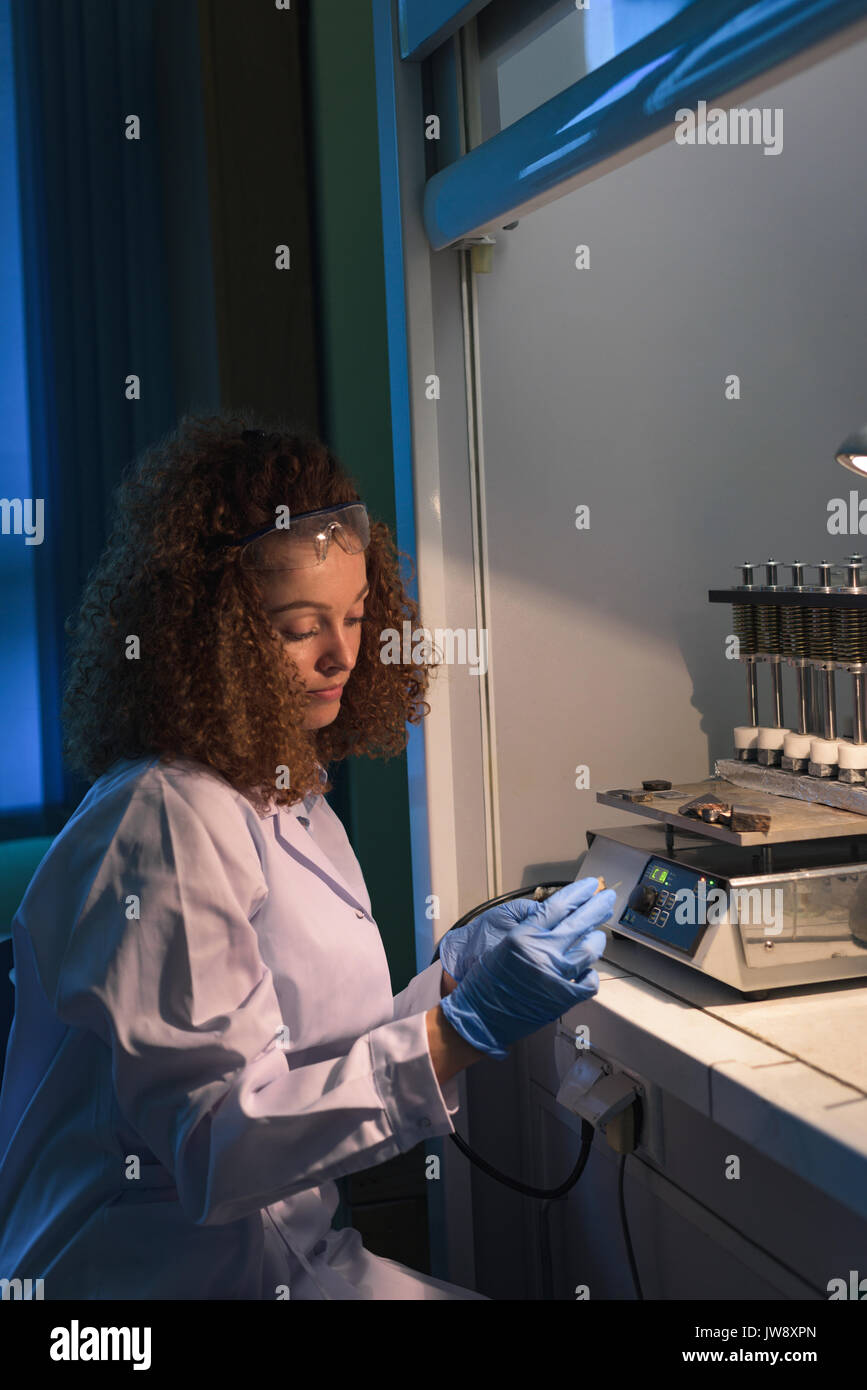 Female university student holding equipment while practicing experiment ...