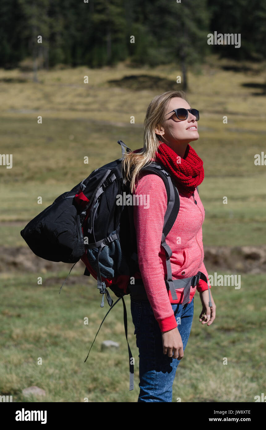 Side view of female hiker with sunglasses standing on field Stock Photo ...