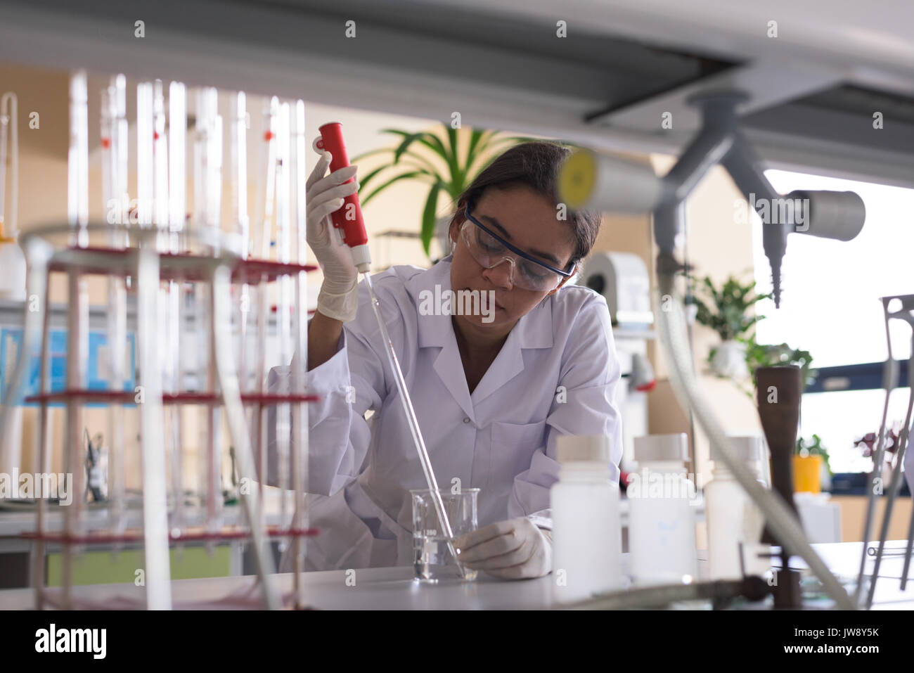 Teenage female university student practicing experiment in chemistry ...