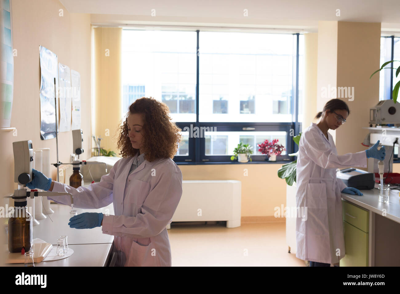 Female students performing chemistry experiment in lab Stock Photo - Alamy
