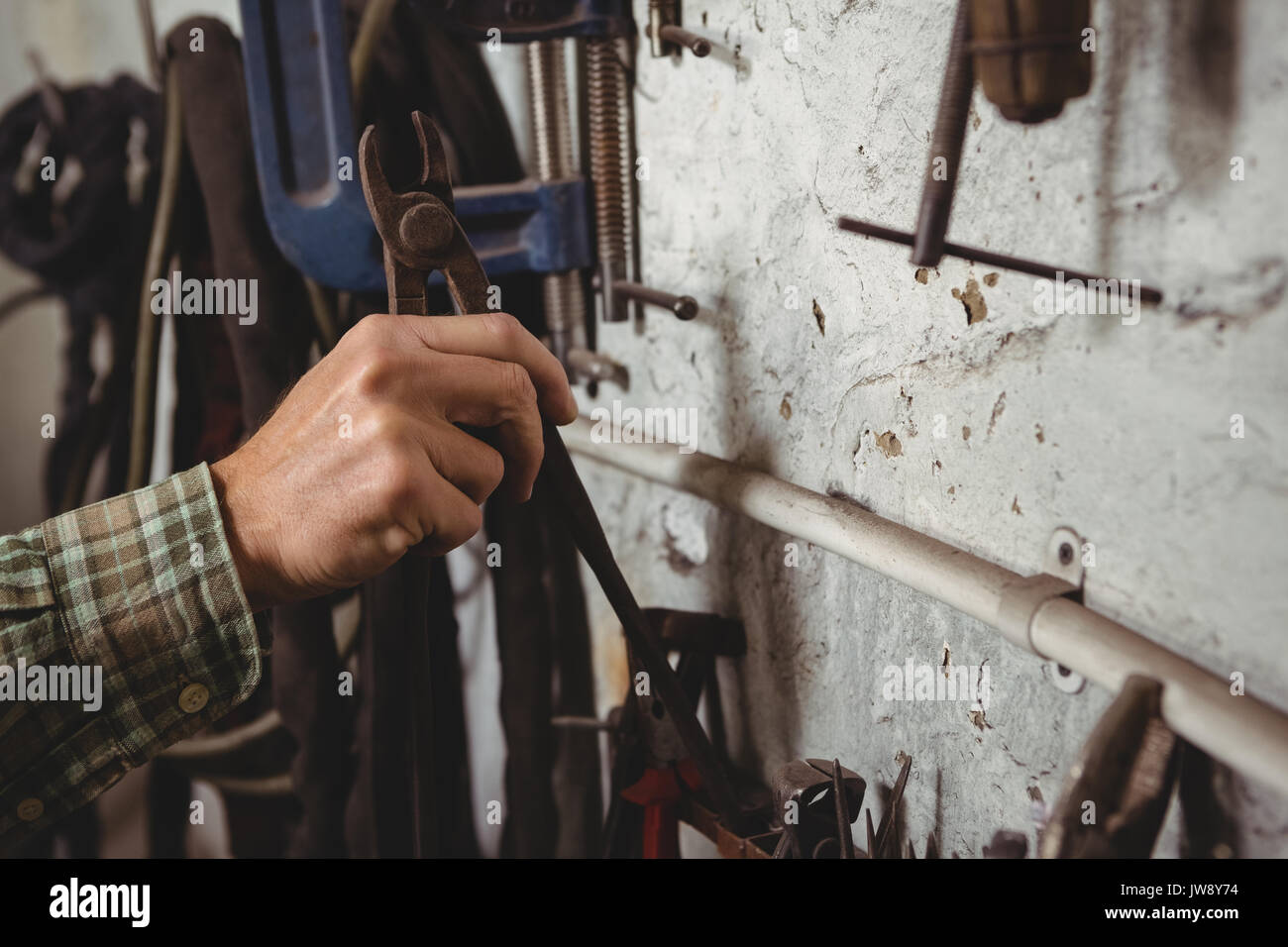 Hand of craftsman removing tool in workshop Stock Photo - Alamy