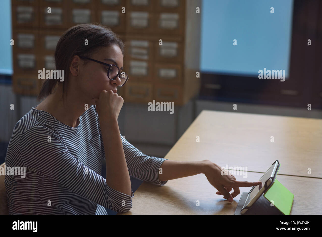 Teenage female student using digital tablet in desk in classroom Stock ...