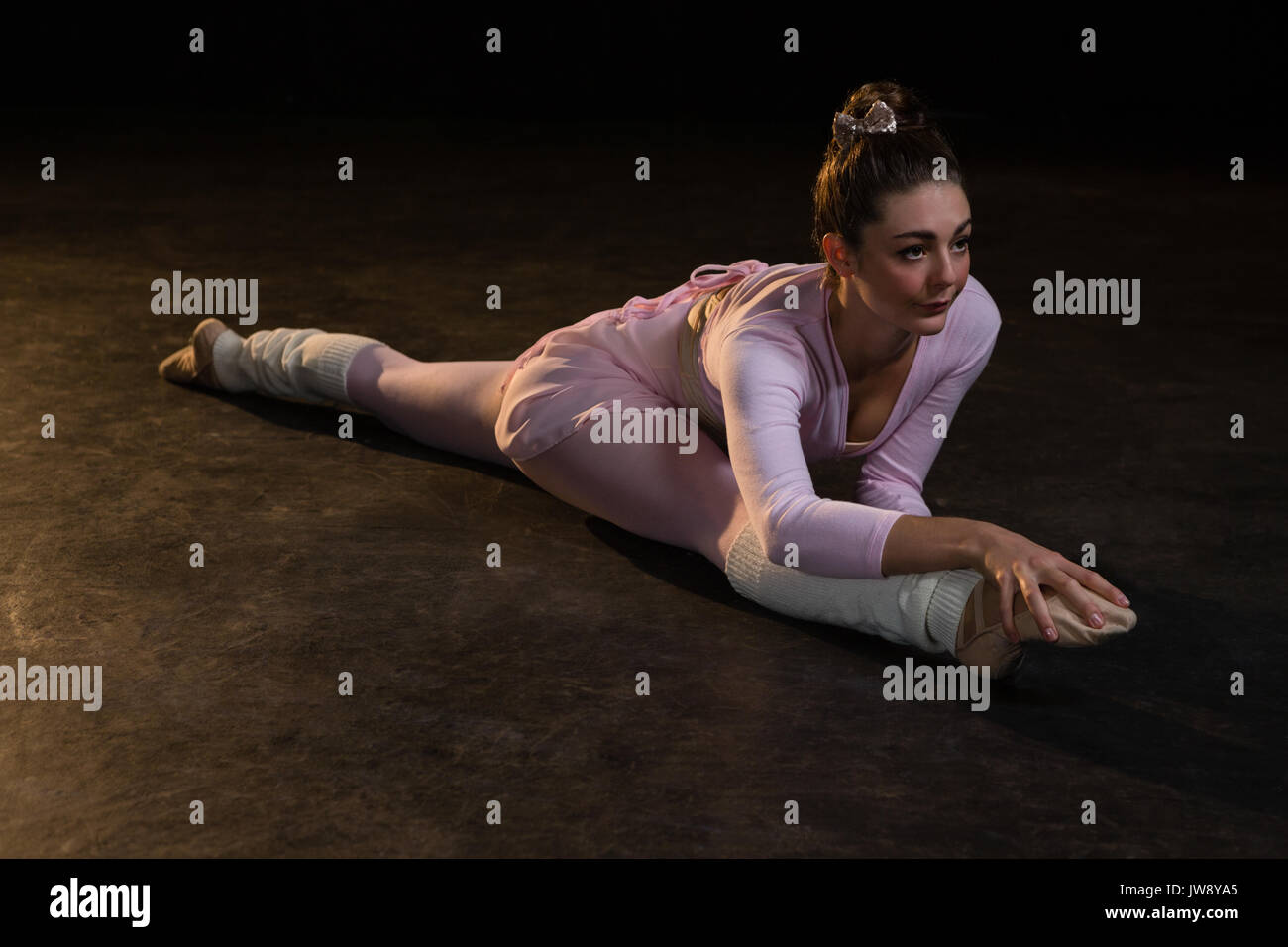 Female ballet dancer stretching before dancing in the studio Stock ...