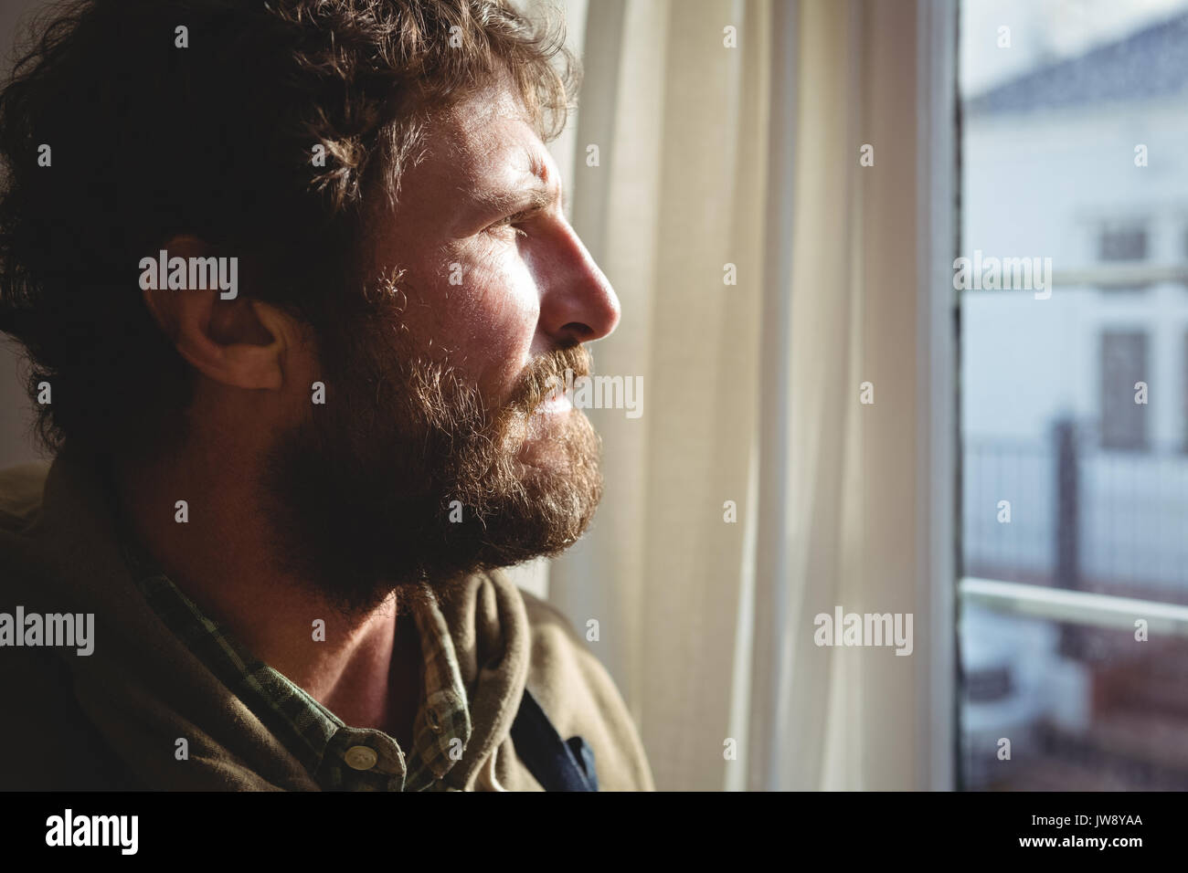 Craftsman looking through window in workshop Stock Photo - Alamy