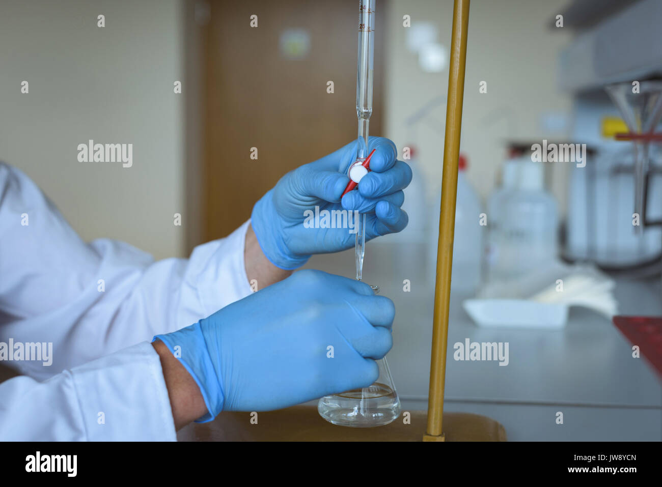 Hand of university student doing a chemical experiment in laboratory ...