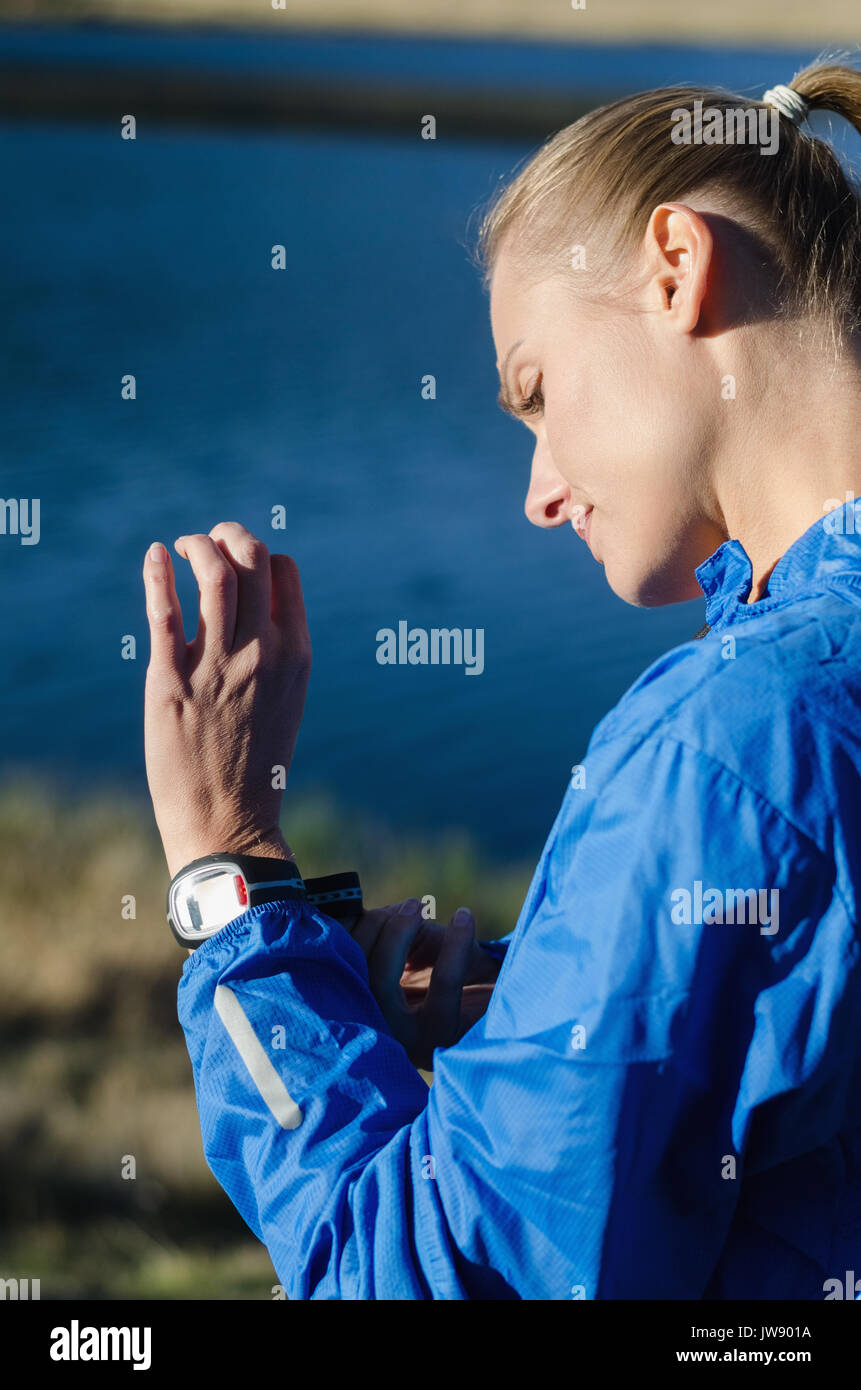Side view of woman wearing wristwatch while standing against lake Stock ...