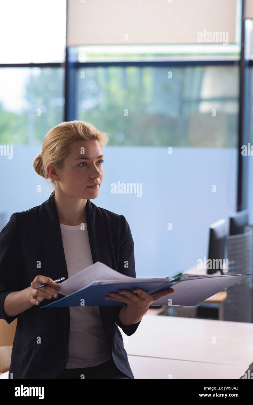 University student holding folder in Classroom Stock Photo - Alamy