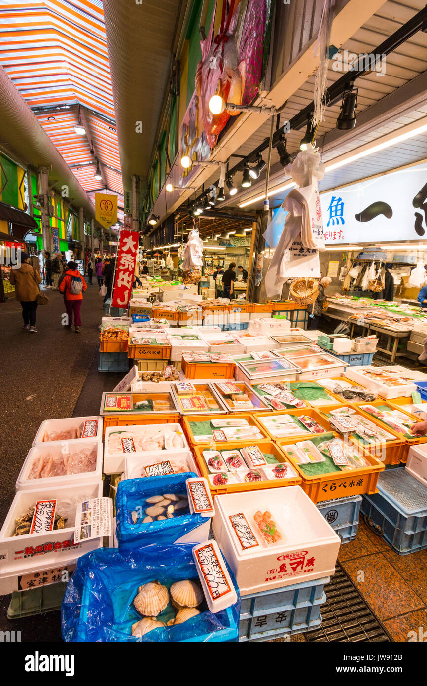 Fresh seafood stall with various types of fish in plastic containers on ...