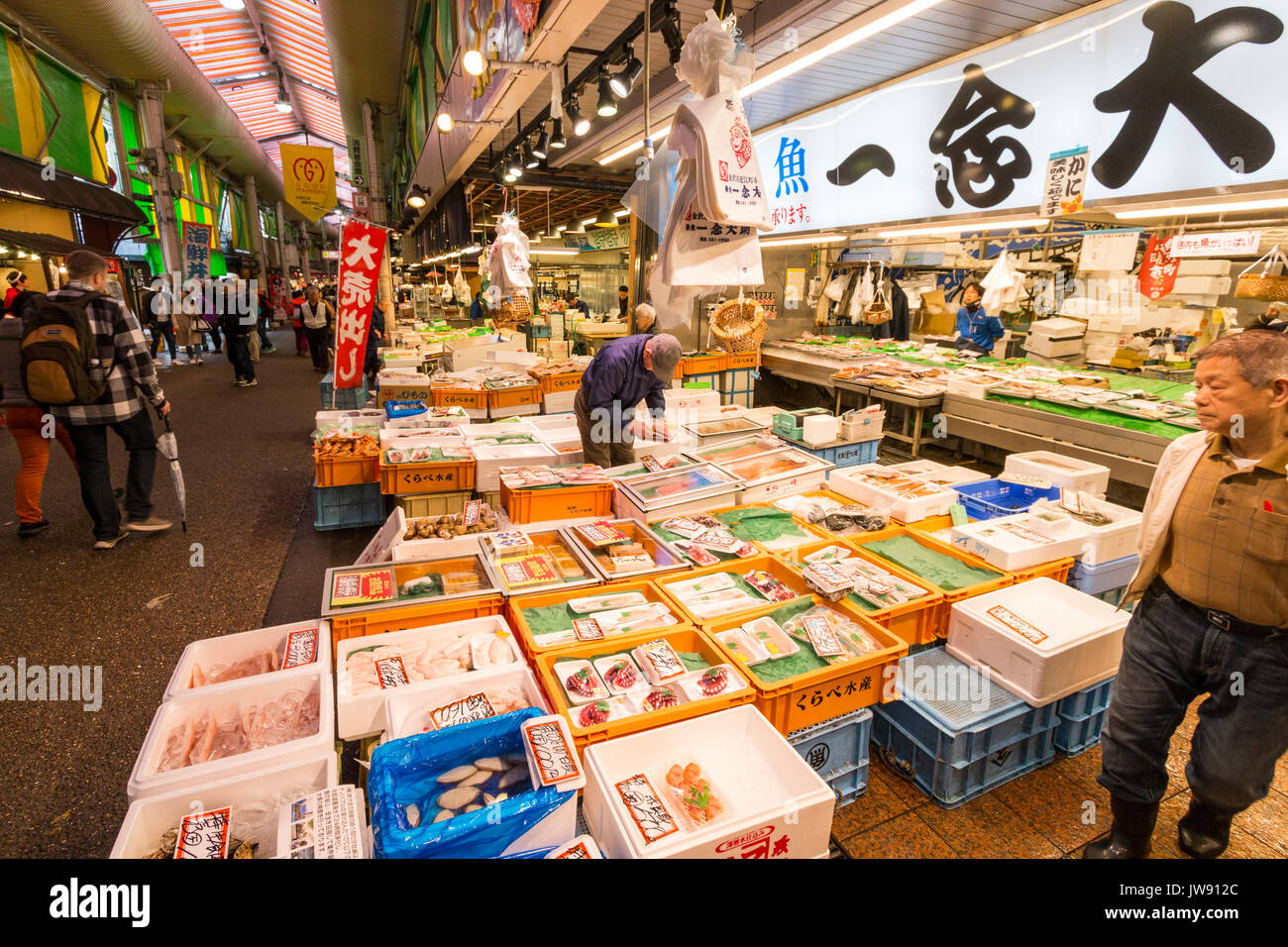 Fresh seafood stall with various types of fish in plastic containers on ...
