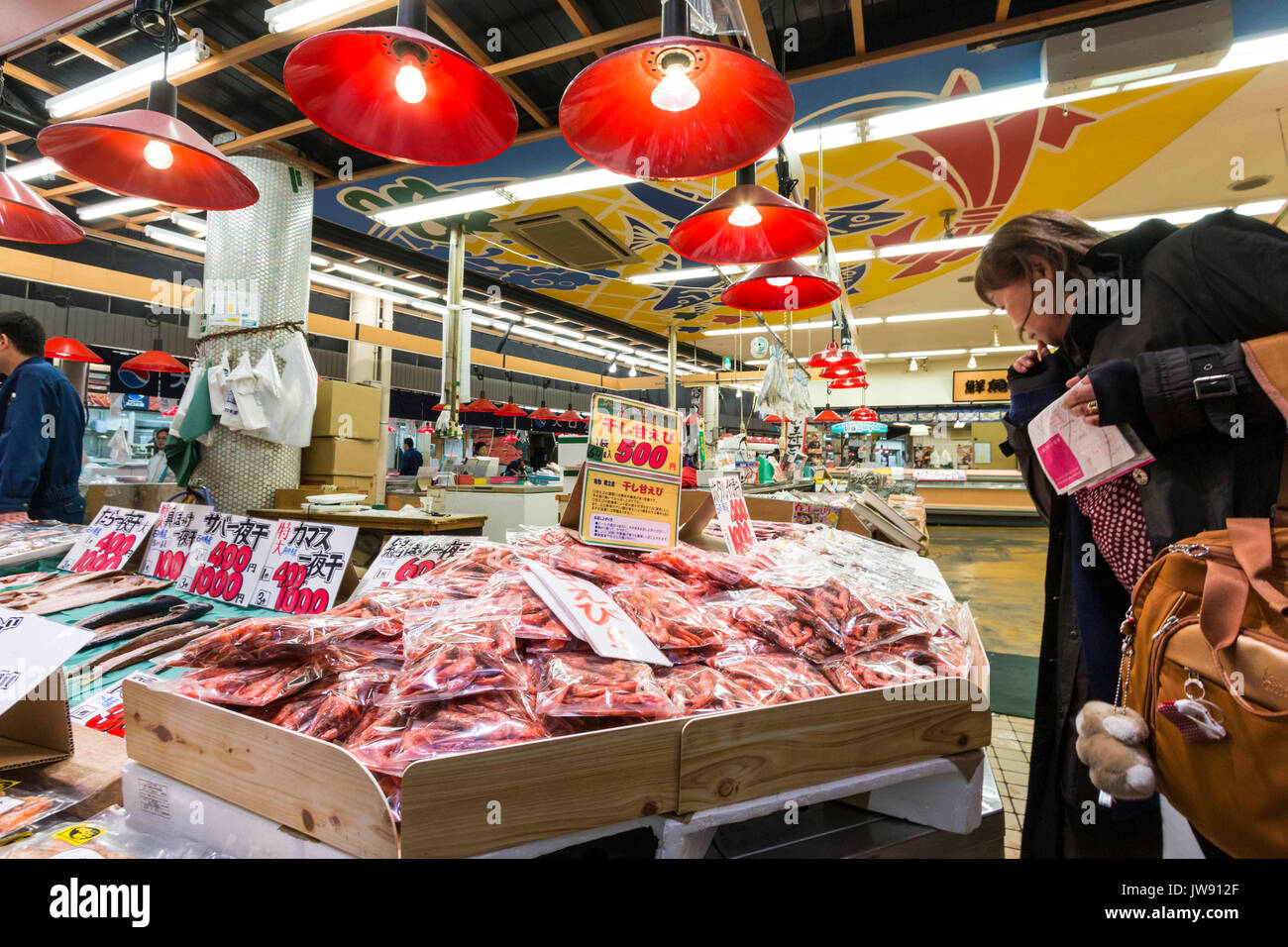Low-angle view of pre-packed plastic shrink wrapped fish on fish-monger ...