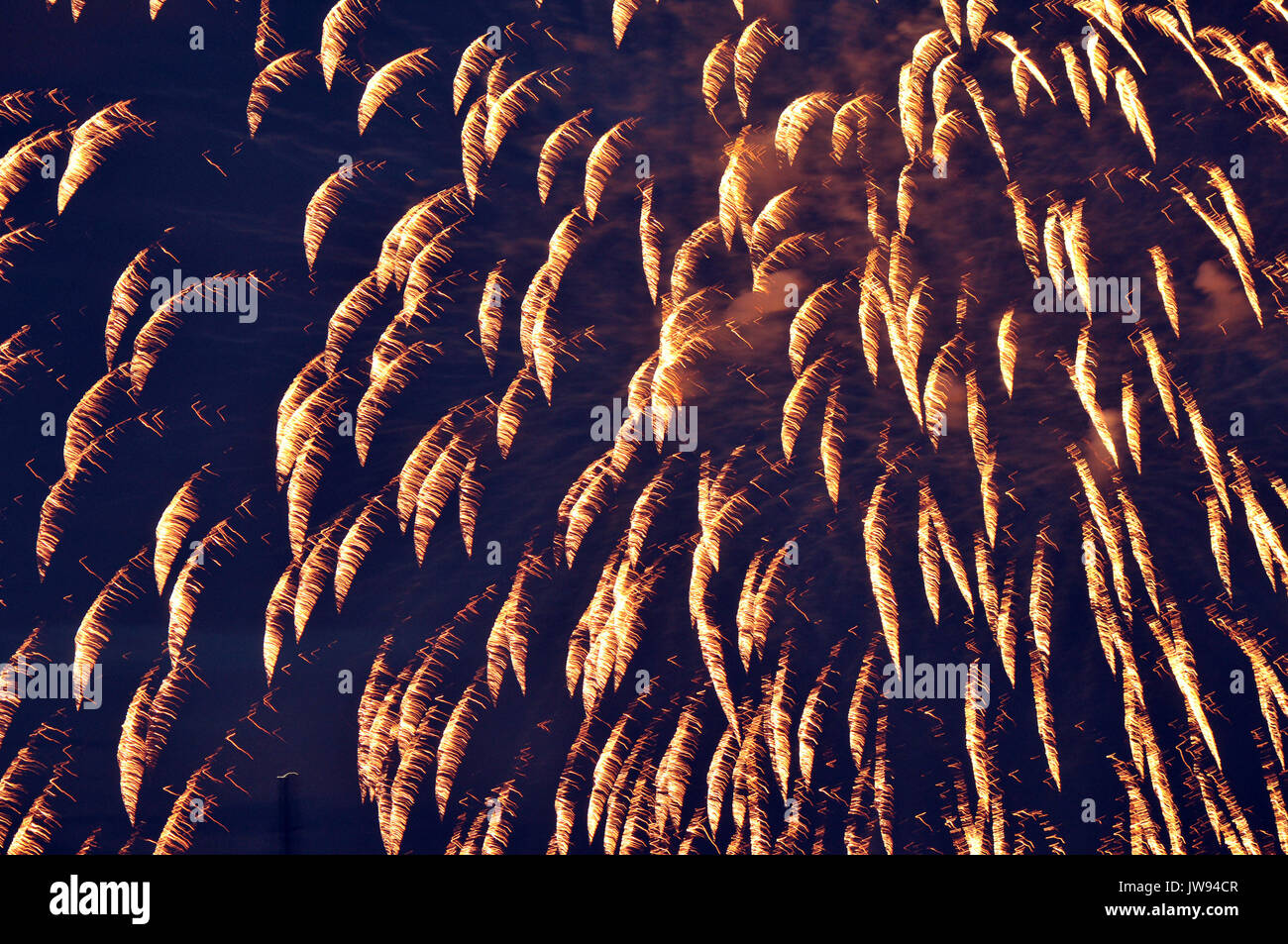 a beautiful firework with golden flames falling from the sky in a ...