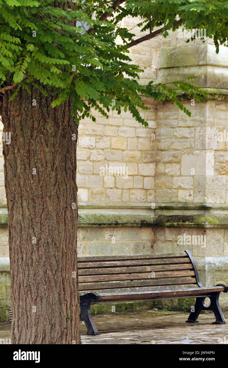 a park bench under a tree outside of a church in the shade next to a ...