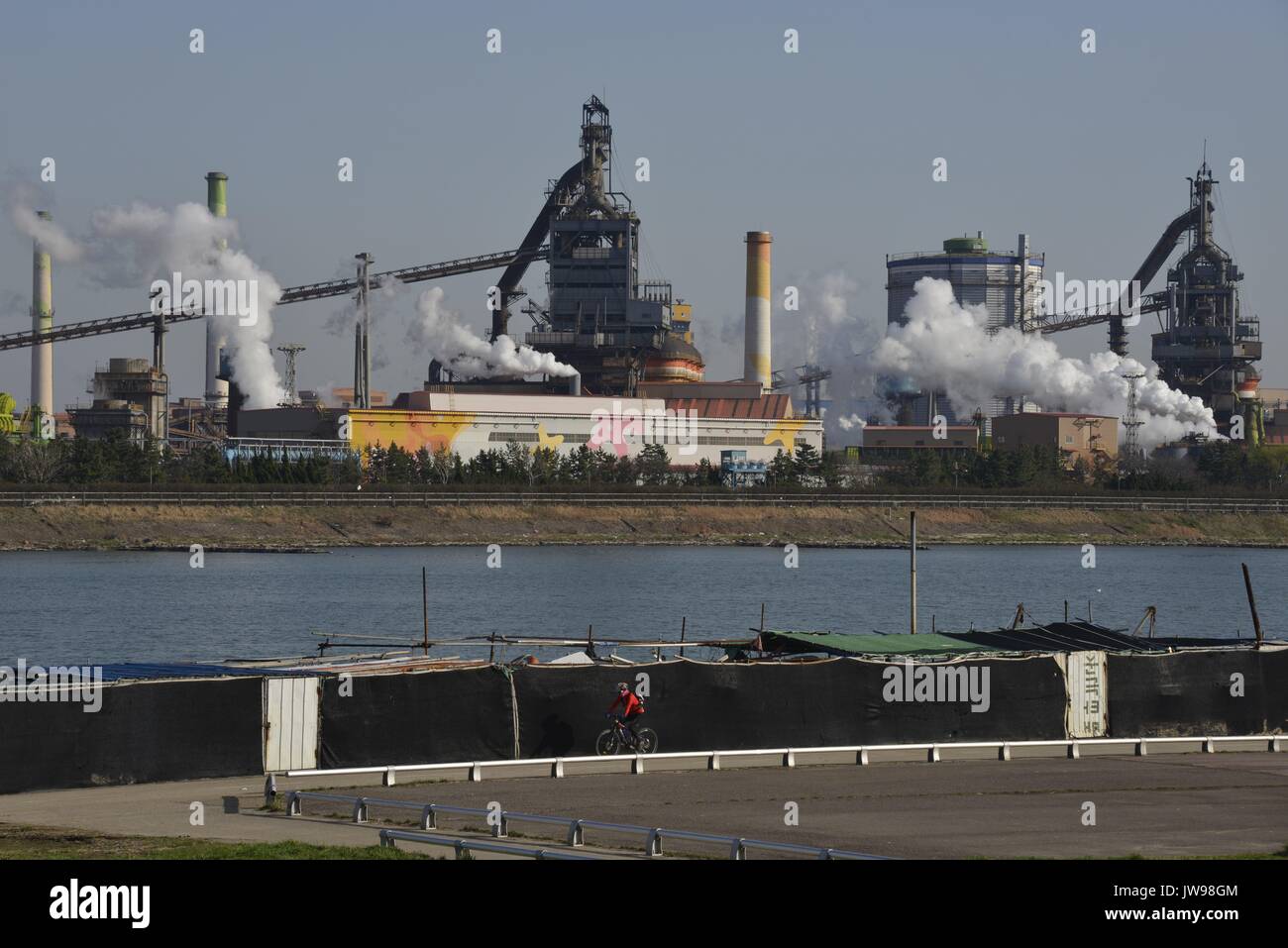A cyclist passes part of the large South Korean POSCO (Pohang Iron and ...