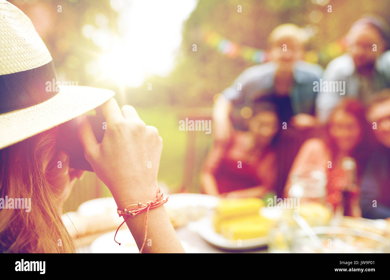 woman photographing friends at summer garden party Stock Photo - Alamy