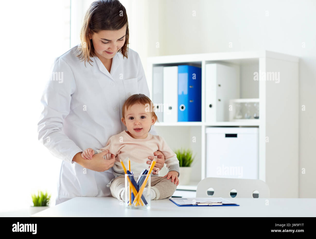 happy doctor or pediatrician with baby at clinic Stock Photo - Alamy