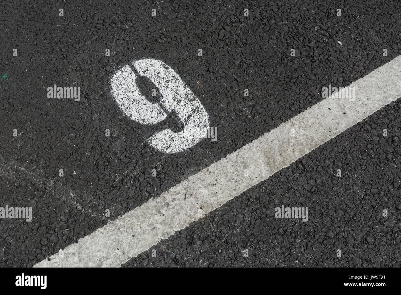 Painted number 9 on tarmac car park / parking lot space. Odd number ...