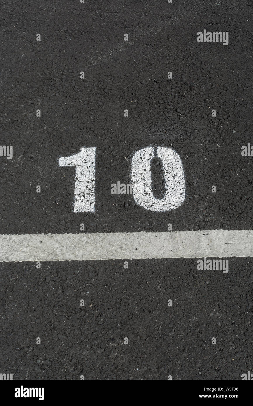 Painted number 10 on tarmac car park / parking lot space. Even number ...