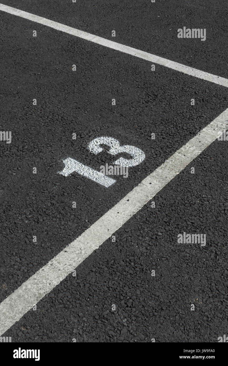 Painted number 13 on tarmac car park / parking lot space. Bad luck and ...