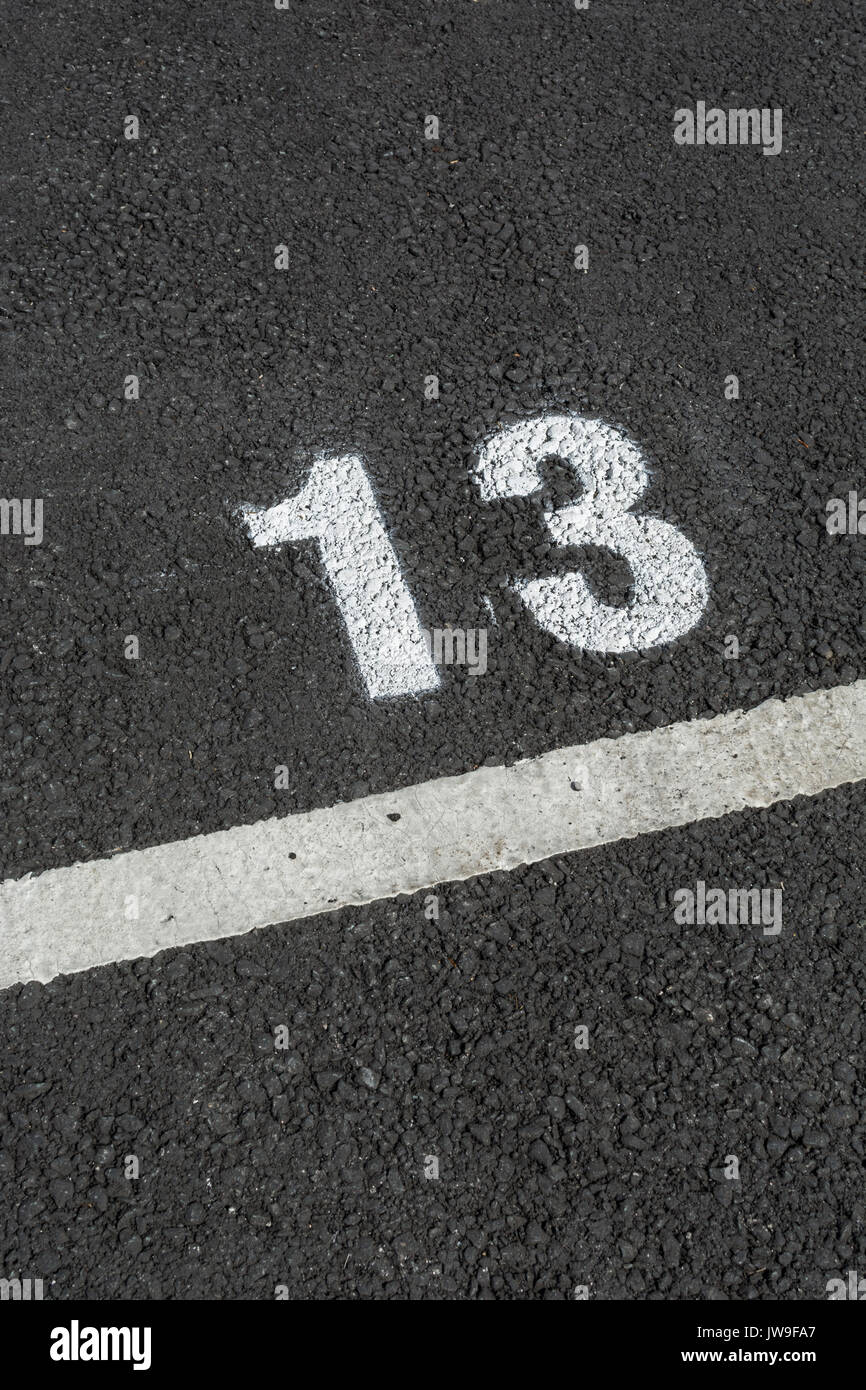 Painted number 13 on tarmac car park / parking lot space. Bad luck and ...