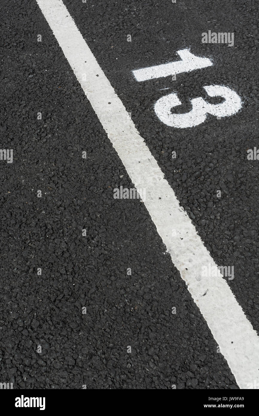 Painted number 13 on tarmac car park / parking lot space. Bad luck and ...