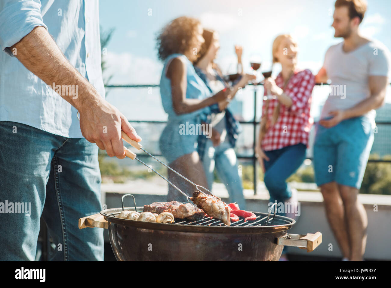 Group of people having barbecue party cooking meat Stock Photo - Alamy
