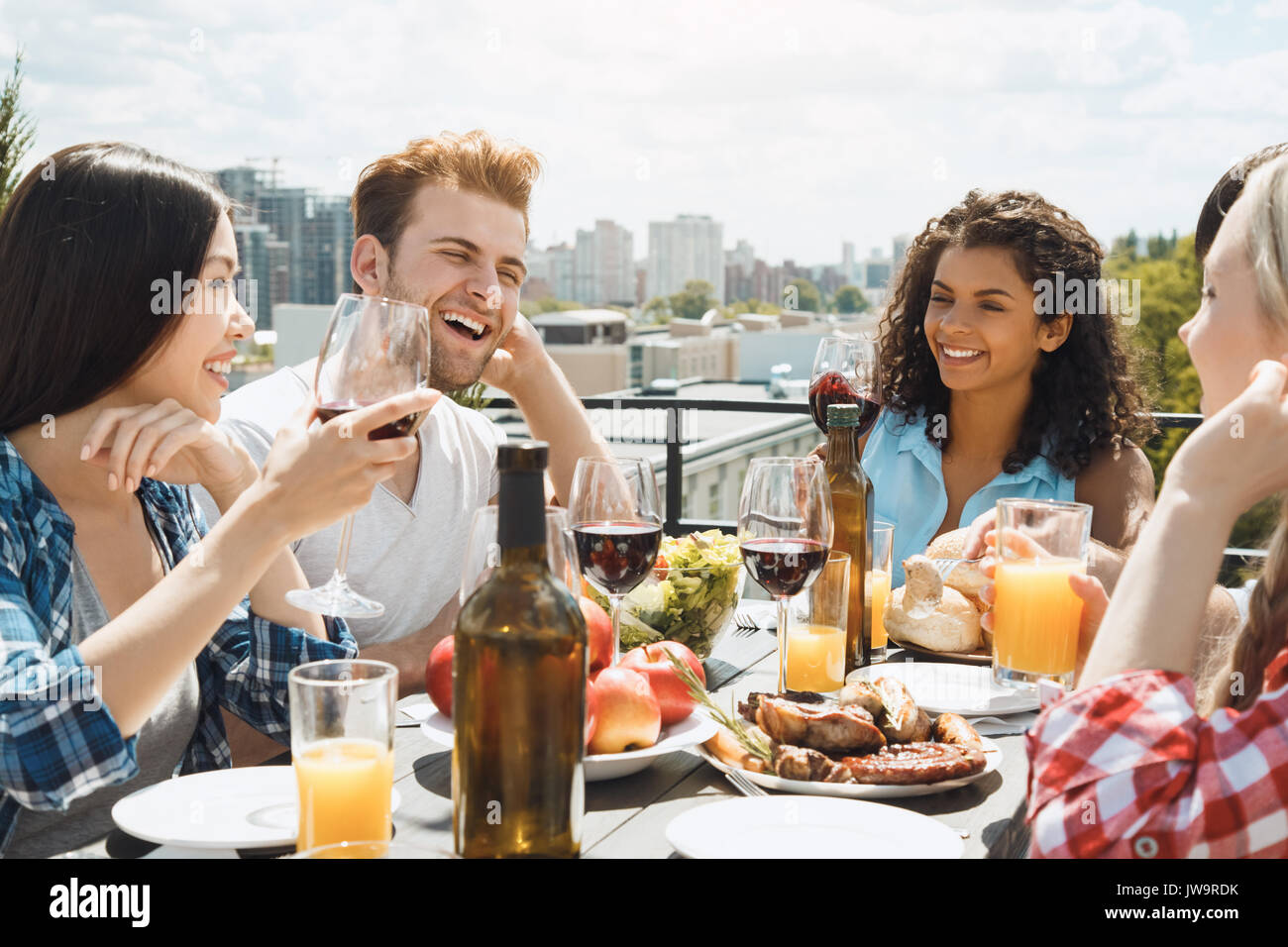 Group of people having barbecue party eating Stock Photo - Alamy