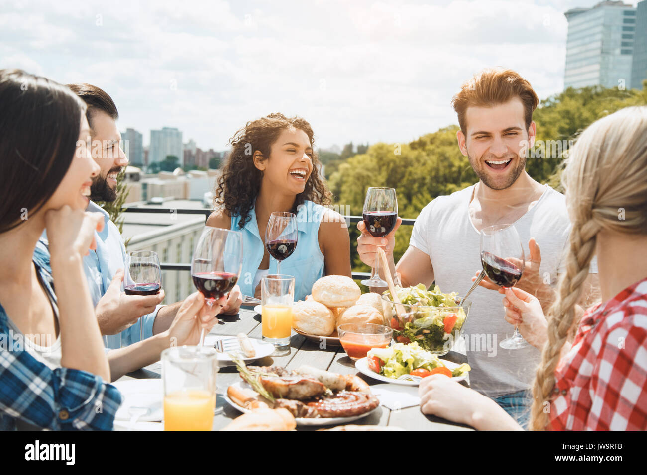 Group of people having barbecue party eating Stock Photo - Alamy