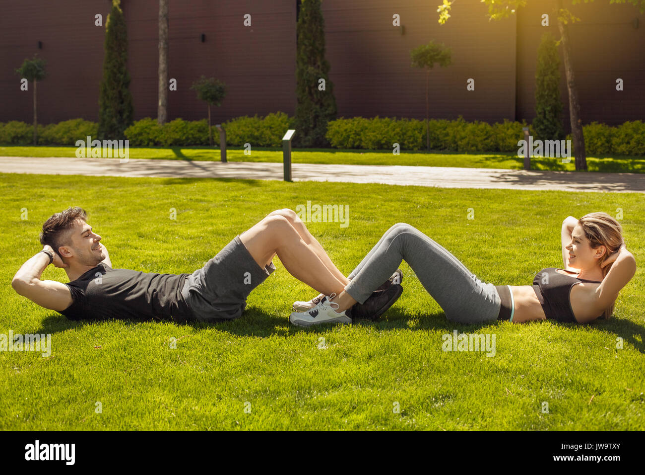 Young man and woman exercise together workout Stock Photo - Alamy