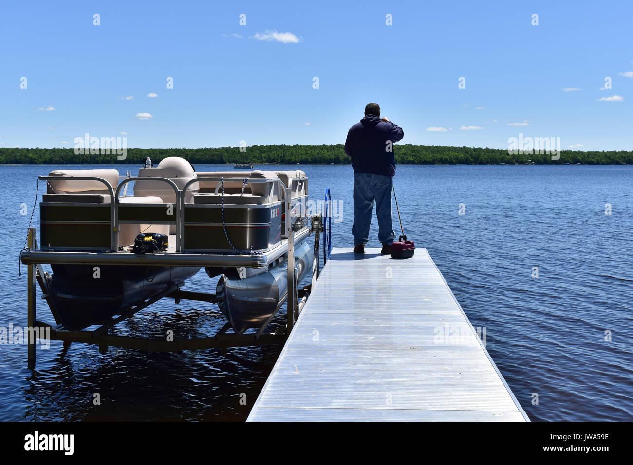 Man fishing off a pier Stock Photo - Alamy