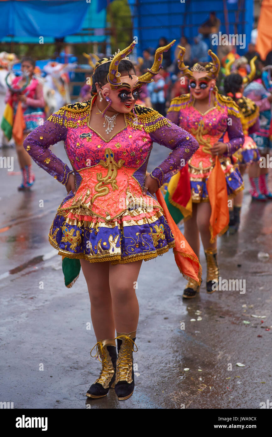 Masked Diablada dancers in ornate costumes parade through the mining ...