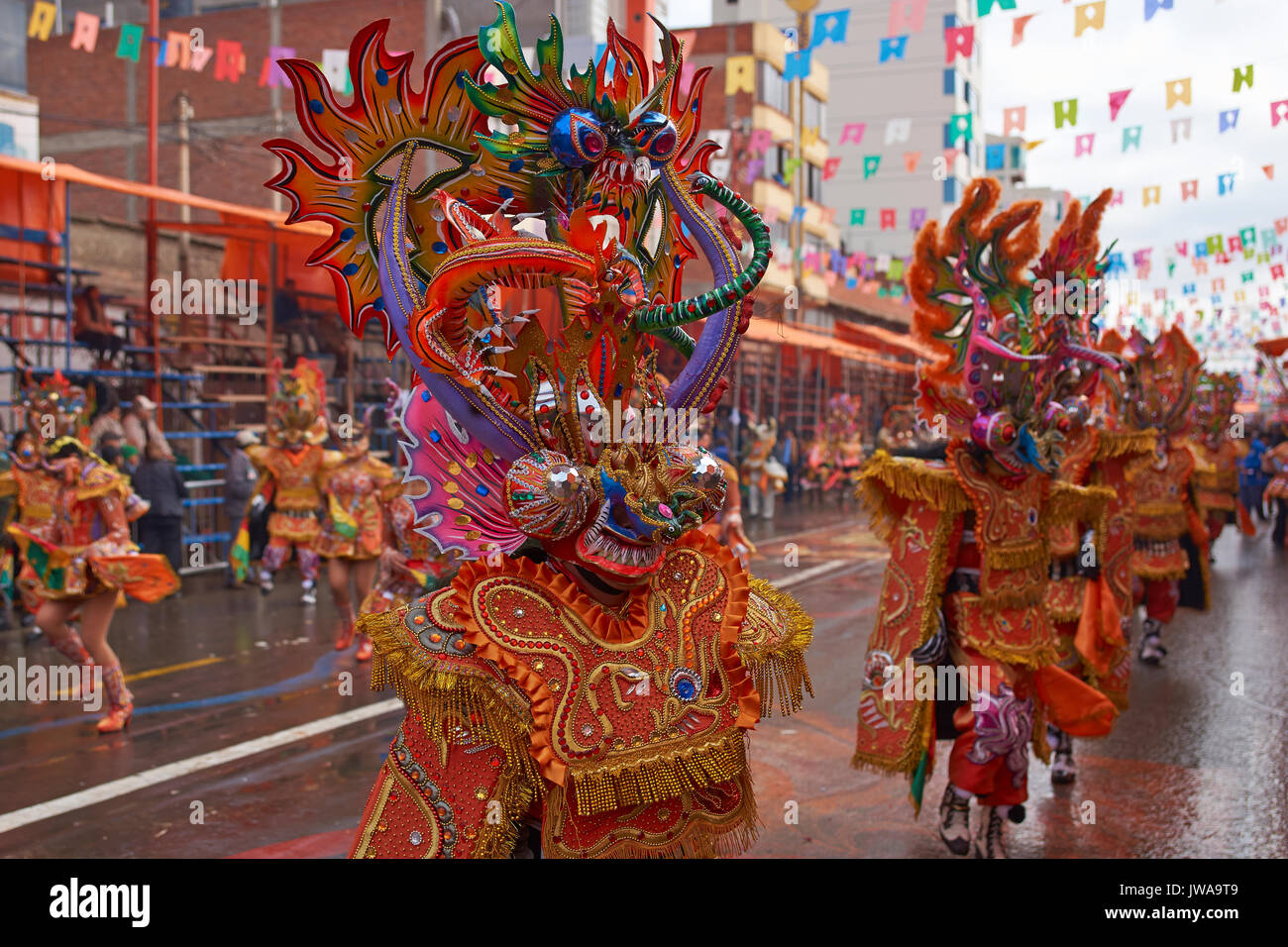 Masked Diablada dancers in ornate costumes parade through the mining ...