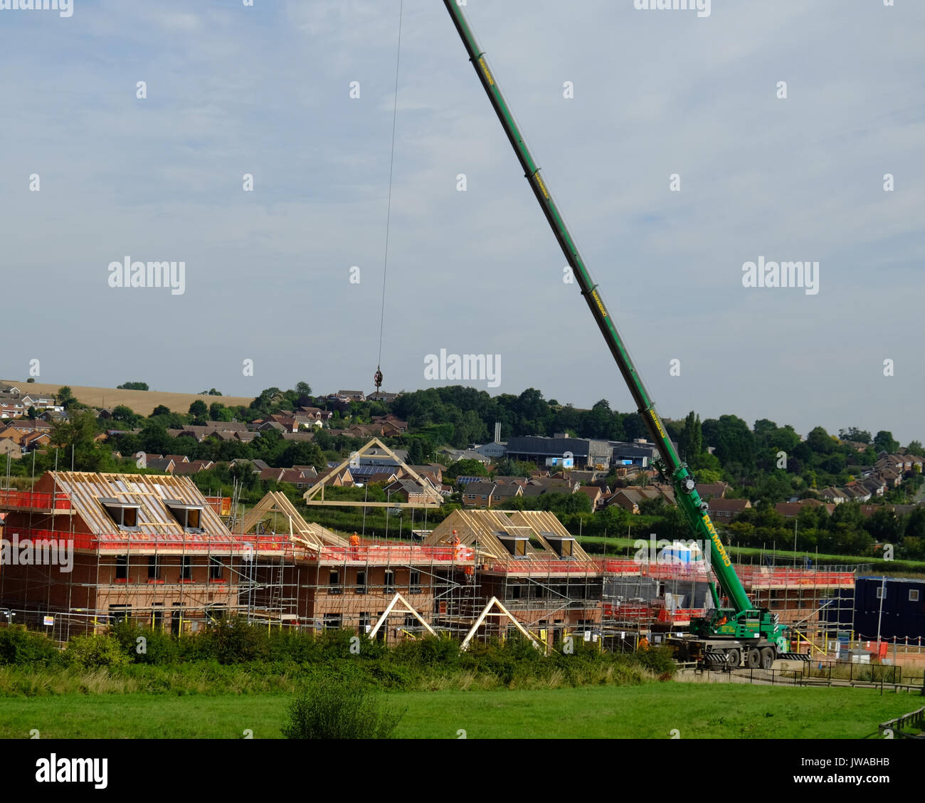 Crane lifting a roof A frame on a new housing estate, Grantham. Lincs ...
