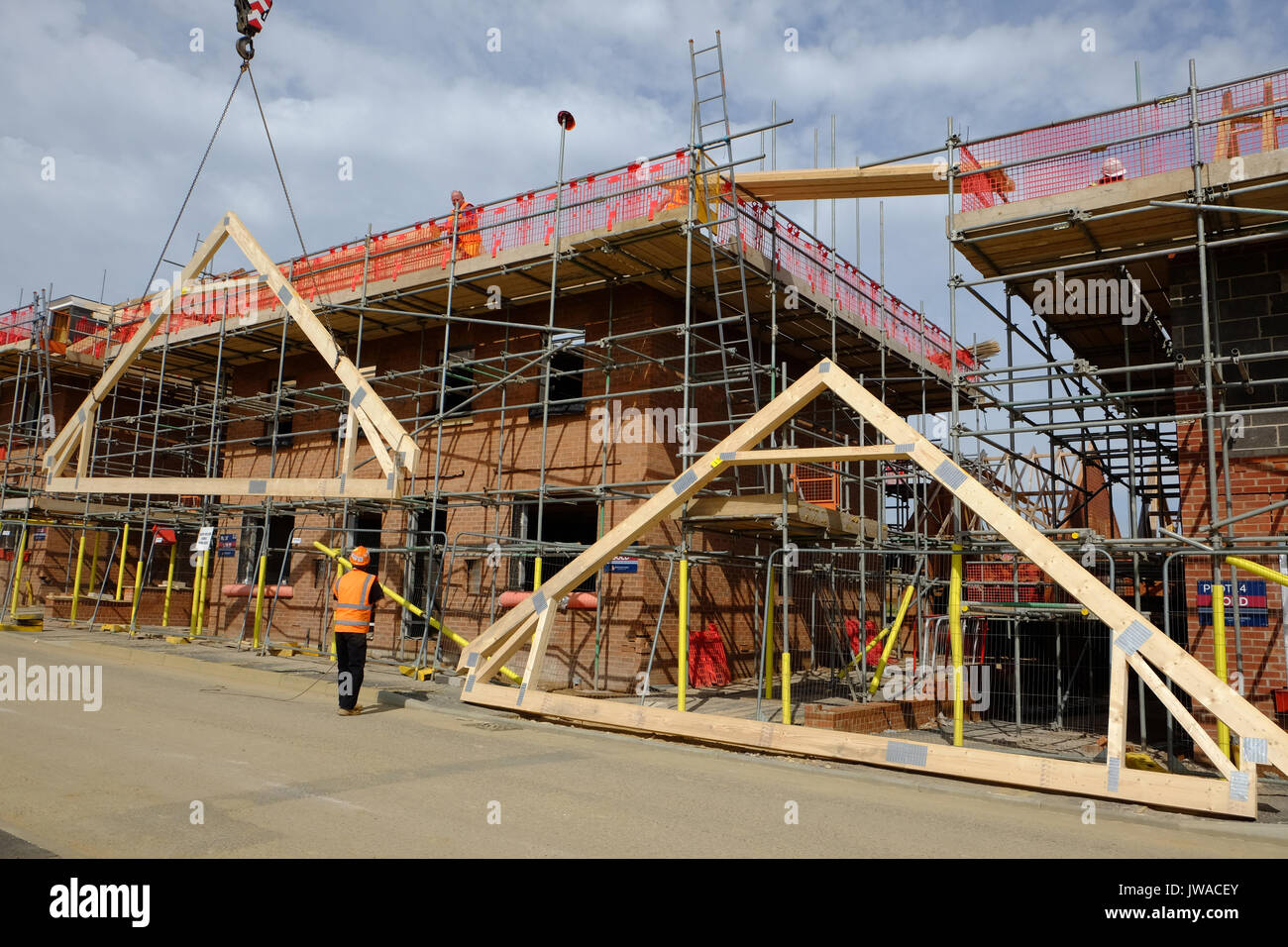 Crane lifting a roof A frame on a new housing estate, Grantham. Lincs ...