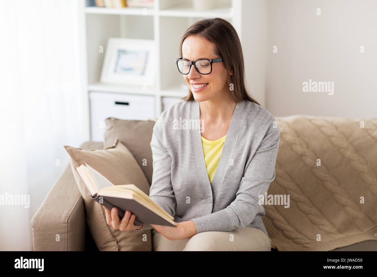 Young woman in glasses reading hi-res stock photography and images - Alamy
