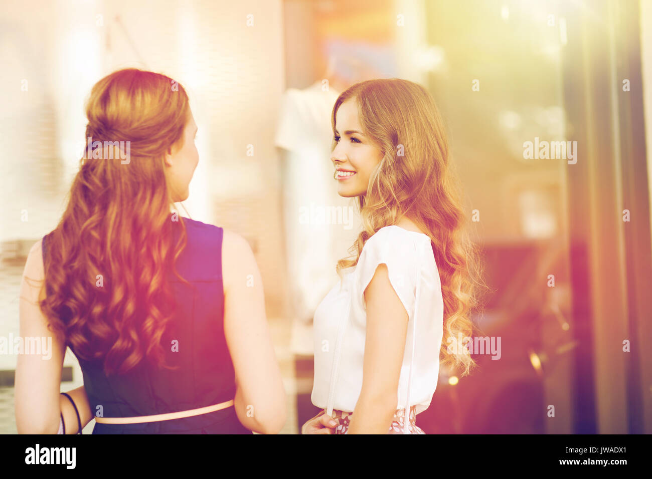 two happy women talking at shop window Stock Photo - Alamy