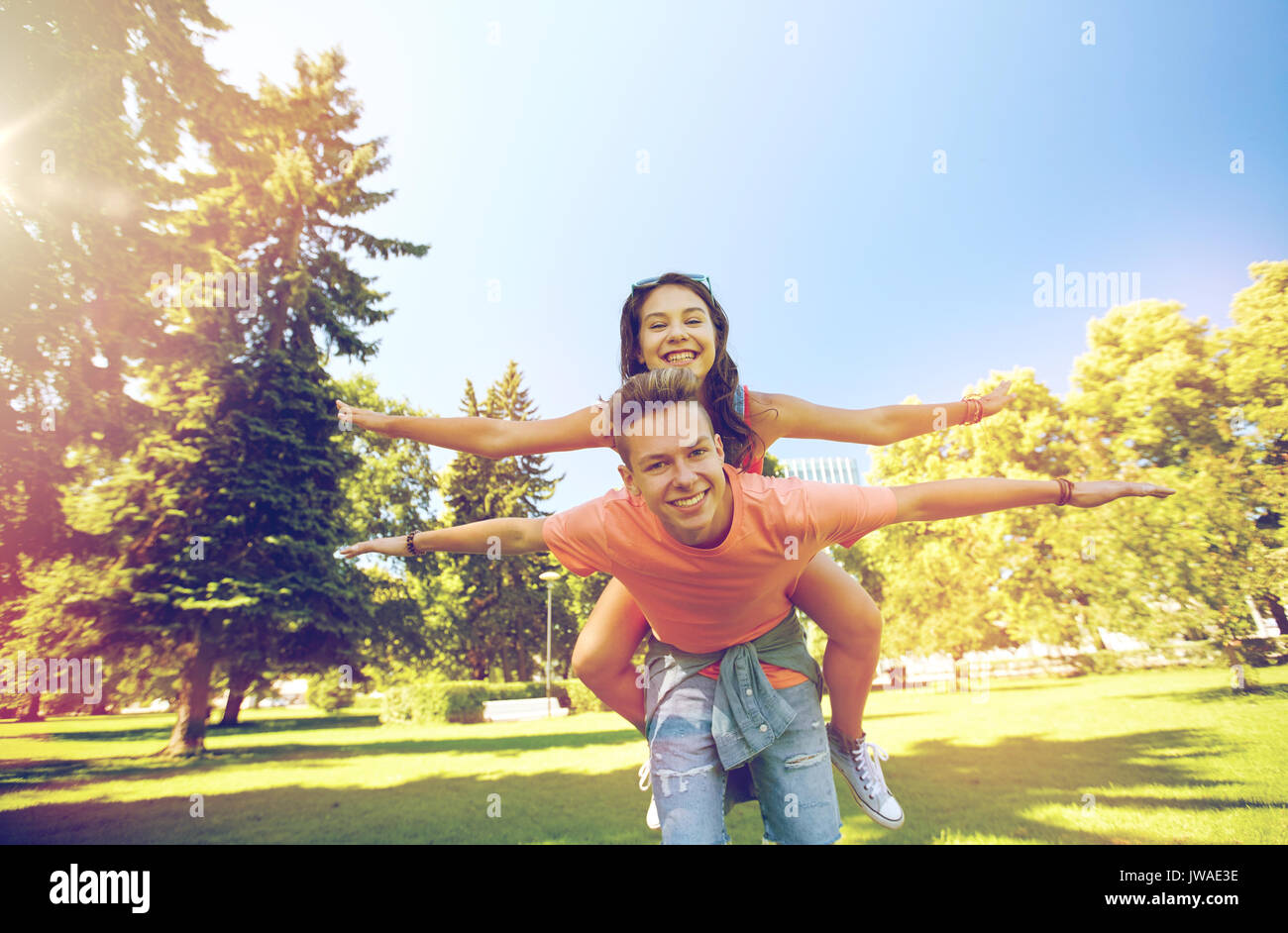 happy teenage couple having fun at summer park Stock Photo - Alamy