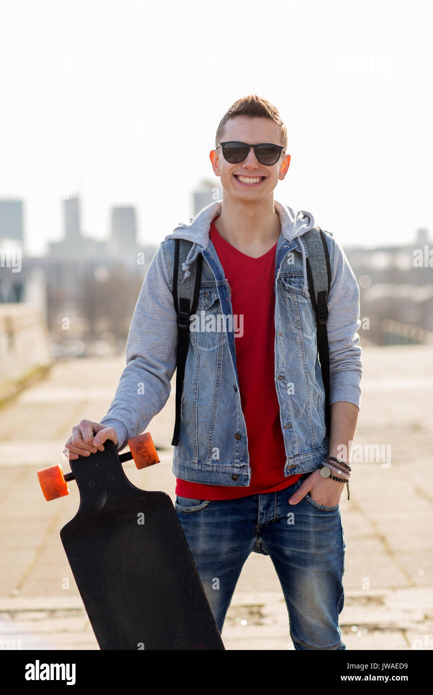 happy young man or teenage boy with longboard Stock Photo - Alamy