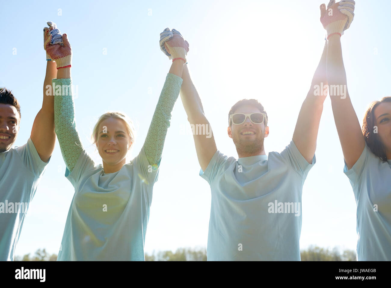 group of happy volunteers holding hands outdoors Stock Photo - Alamy