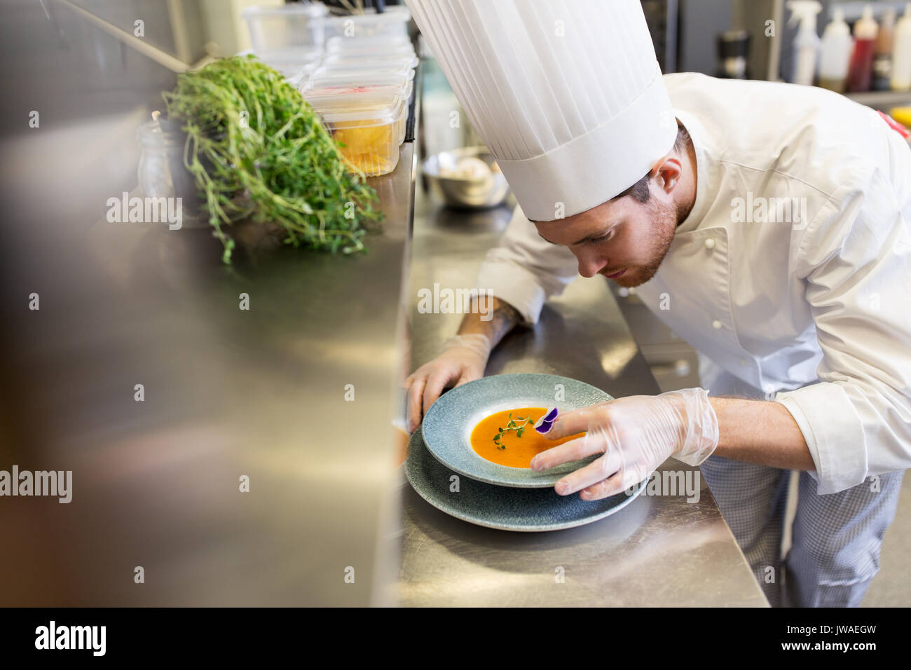 male chef decorating dish with pansy flower Stock Photo - Alamy