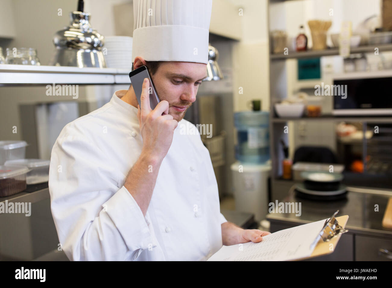 chef calling on smartphone at restaurant kitchen Stock Photo - Alamy