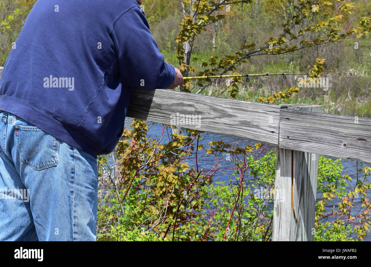 Man fishing off a bridge Stock Photo - Alamy