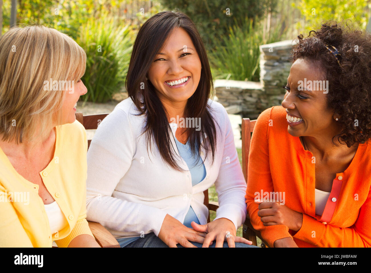 Diverse group of friends talking and laughing Stock Photo - Alamy