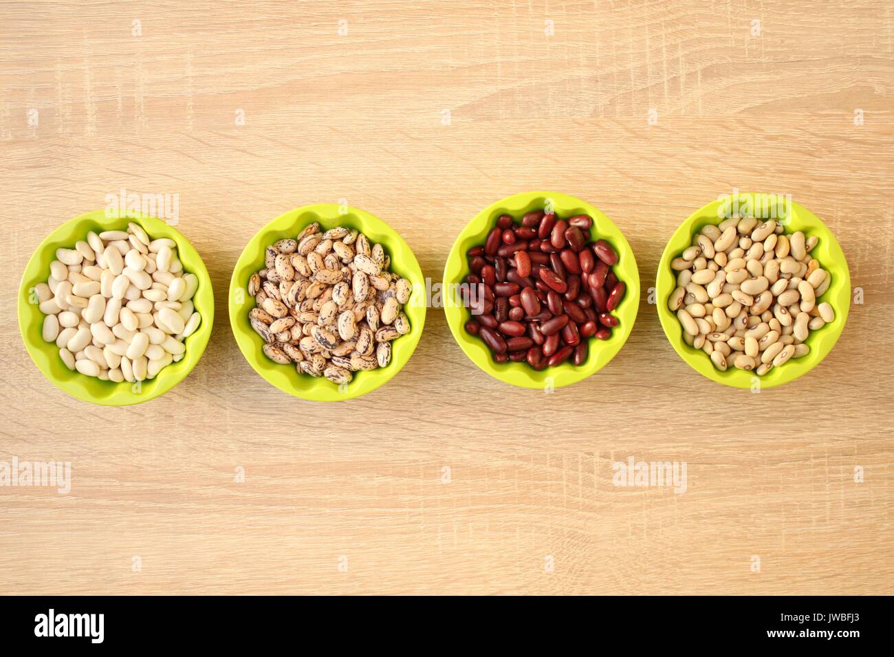 Top view of four varieties of common bean in green plastic bowls Stock ...
