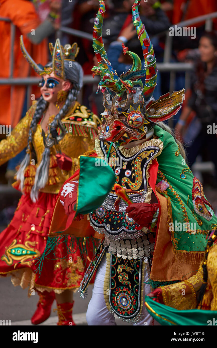 Masked Diablada dancers in ornate costumes parade through the mining ...