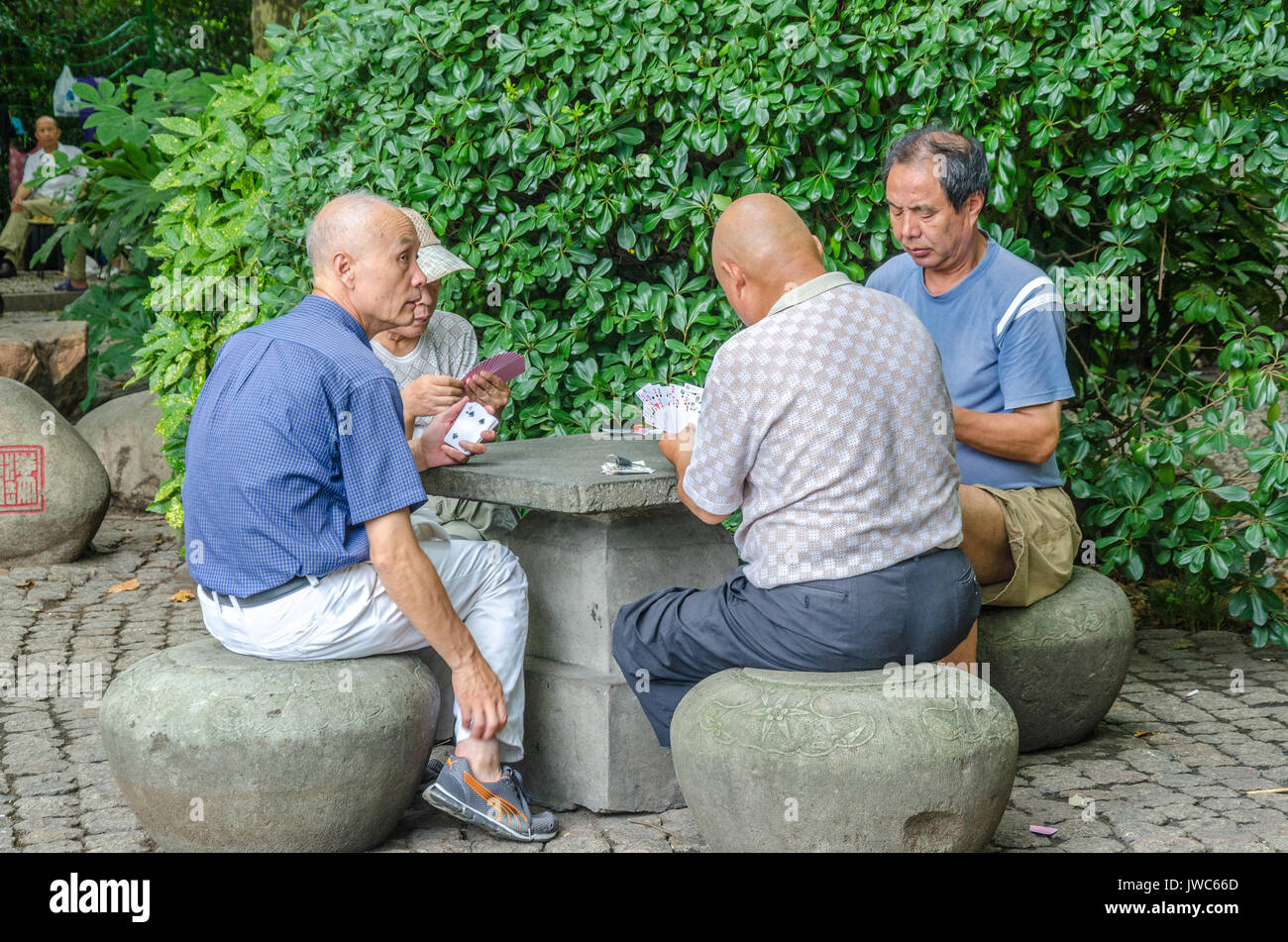Men sitting outside at tables in The People's Park in Shanghai playing ...