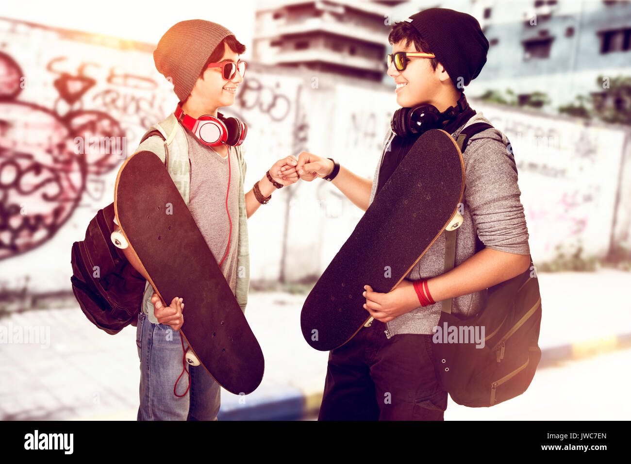 Happy young skateboarders greeting each other on the street, best ...