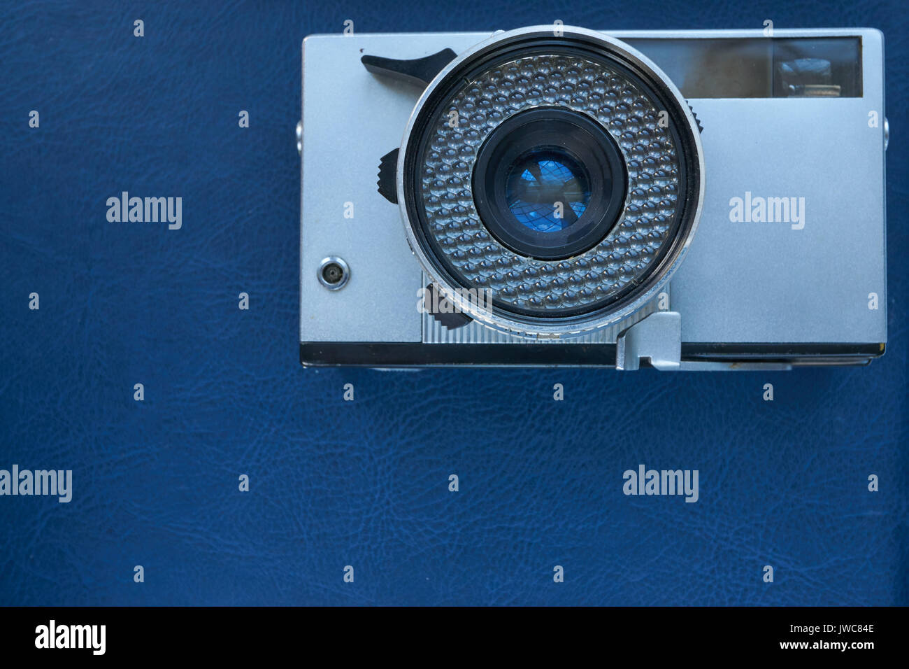 retro vintage film still photo camera on blue leather surface. flat lay ...