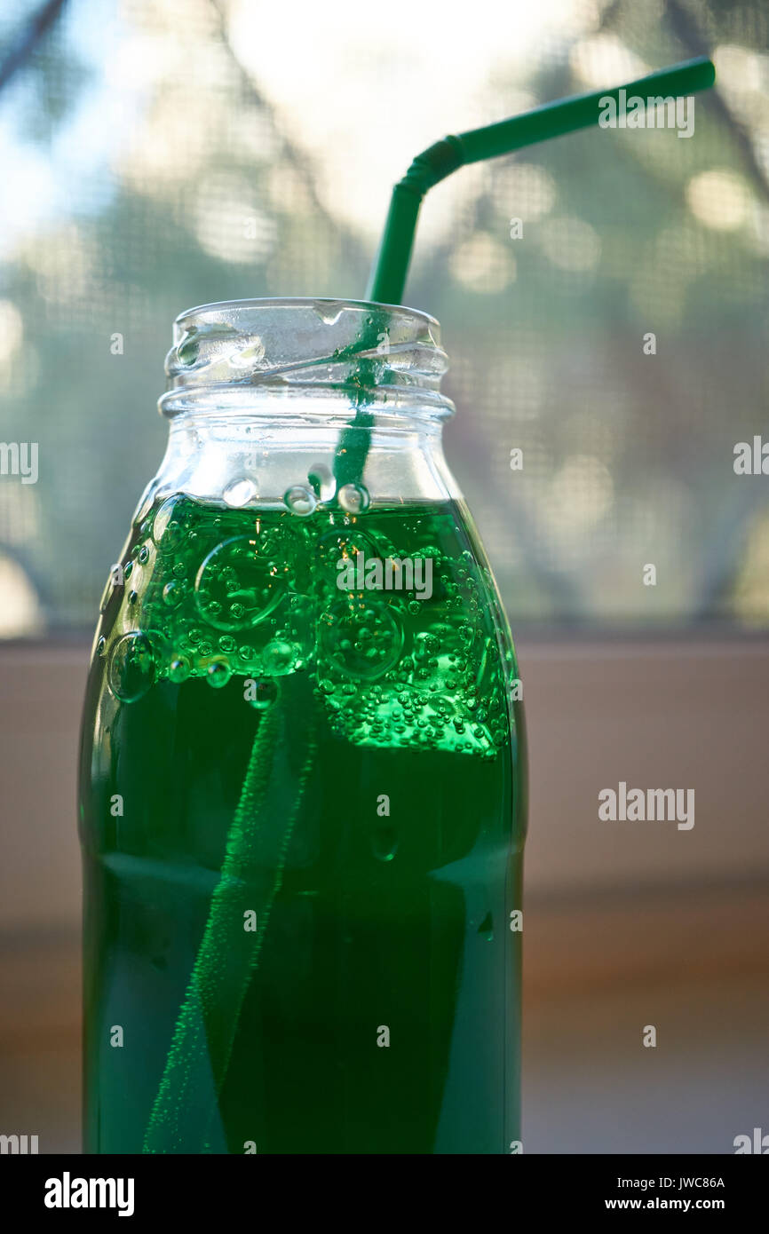 bottle of green aerated water with drinking straw on pub desk Stock ...