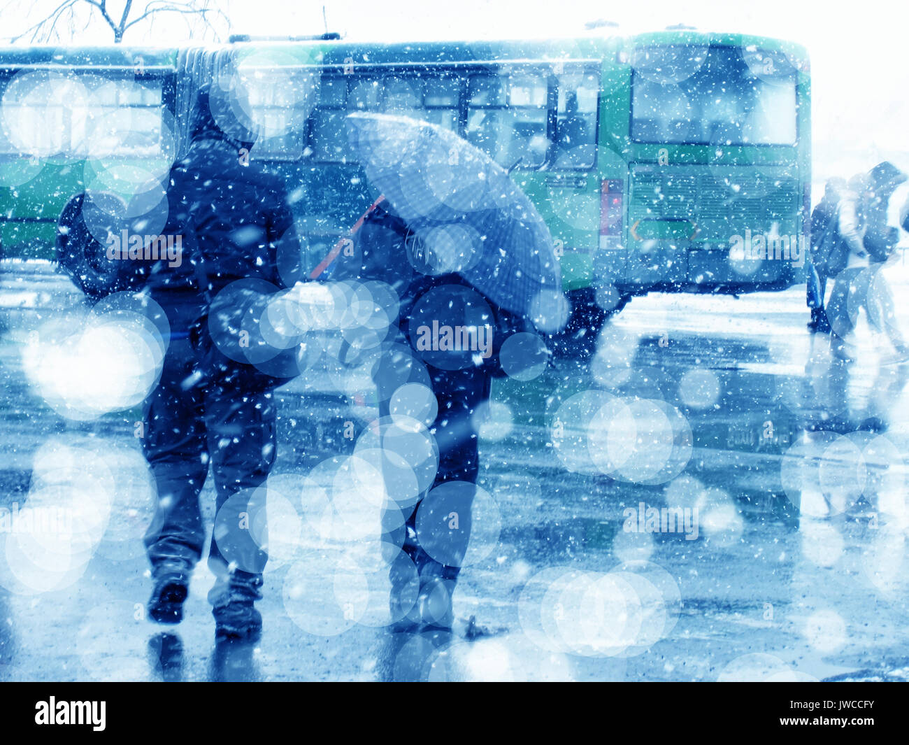 people walking on city street under snowing Stock Photo - Alamy