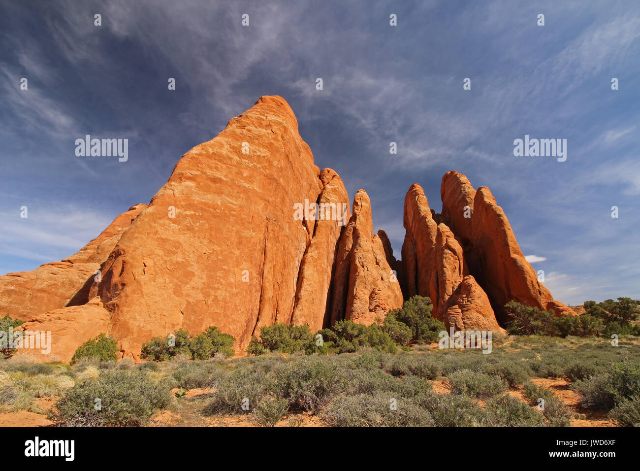 The desert sun shines on a tall sandstone rock formation in the ...